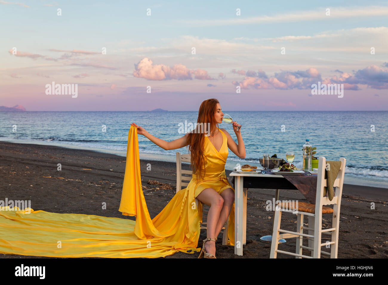Beautiful woman in yellow dress on the seashore Stock Photo - Alamy