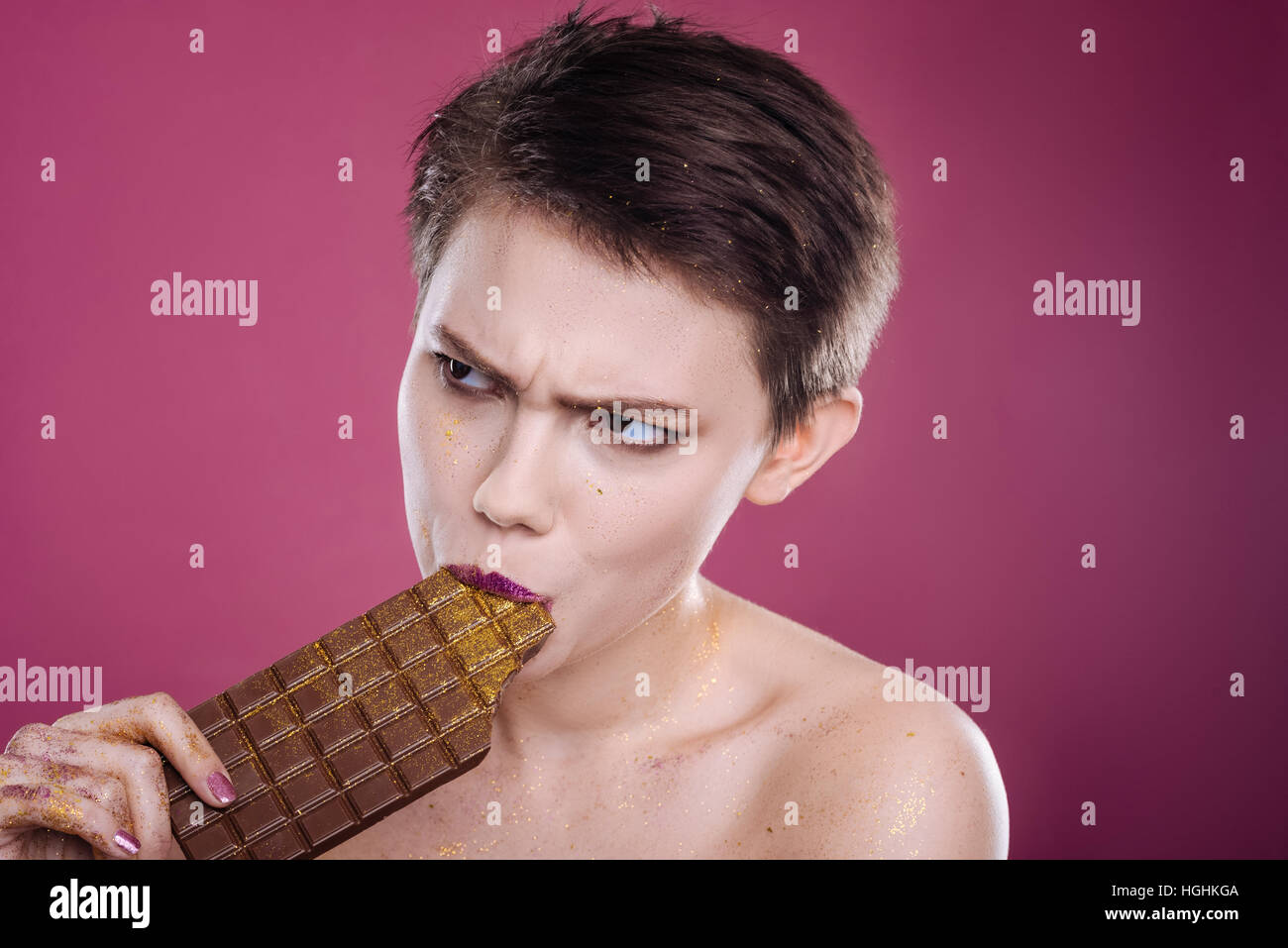 Pleasant woman eating chocolate bar Stock Photo - Alamy
