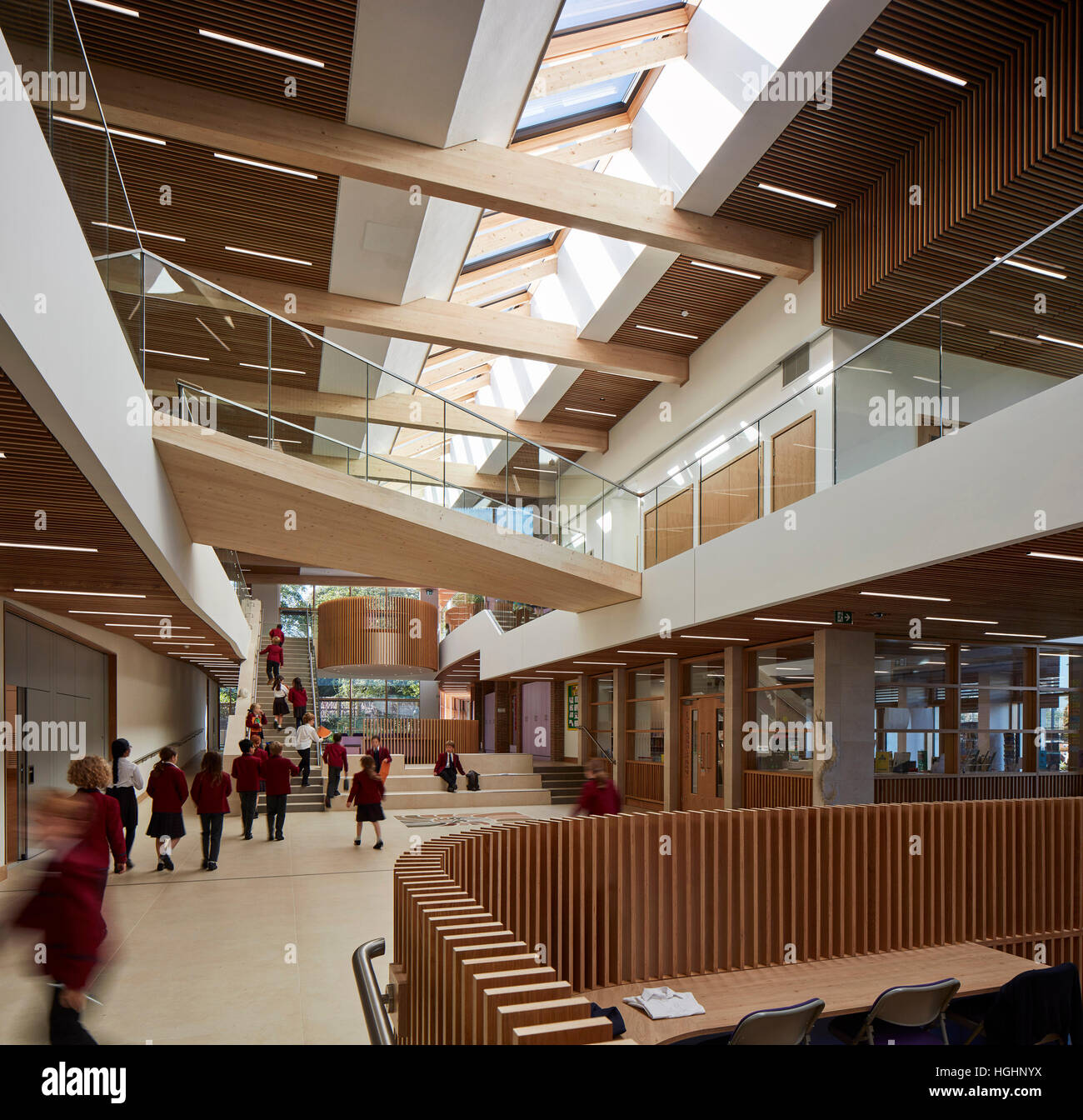 Sunlit atrium with students passing. Highgate Shool, London, United ...