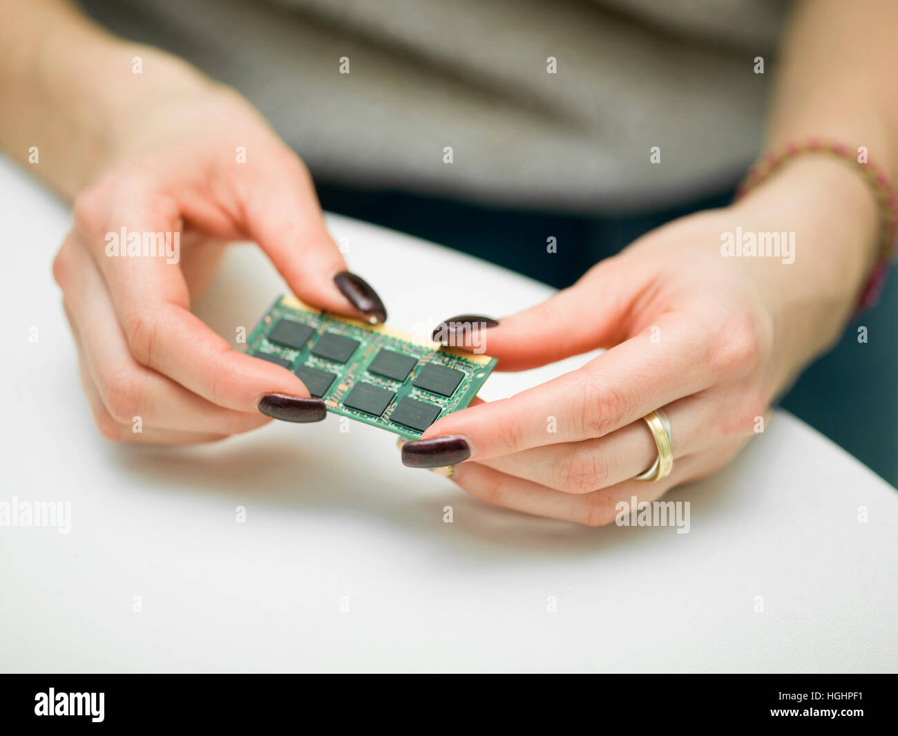 Female hands with manicure holding a memory expansion chip, shallow ...