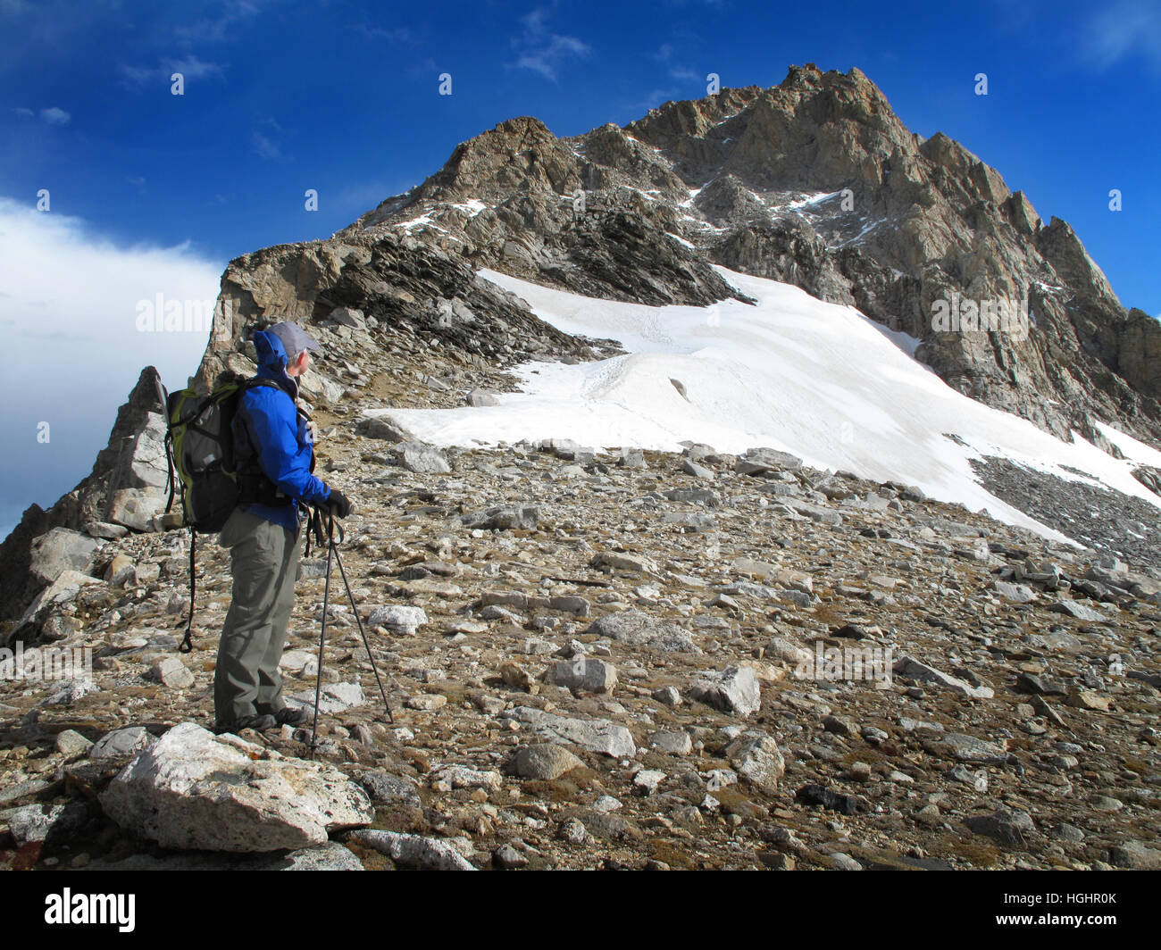 Man hiking climbing rugged mountain peaks in wilderness Stock Photo - Alamy