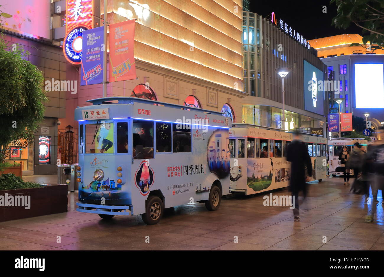 People ride tourist shuttle bus on Nanjing Road shopping street in ...