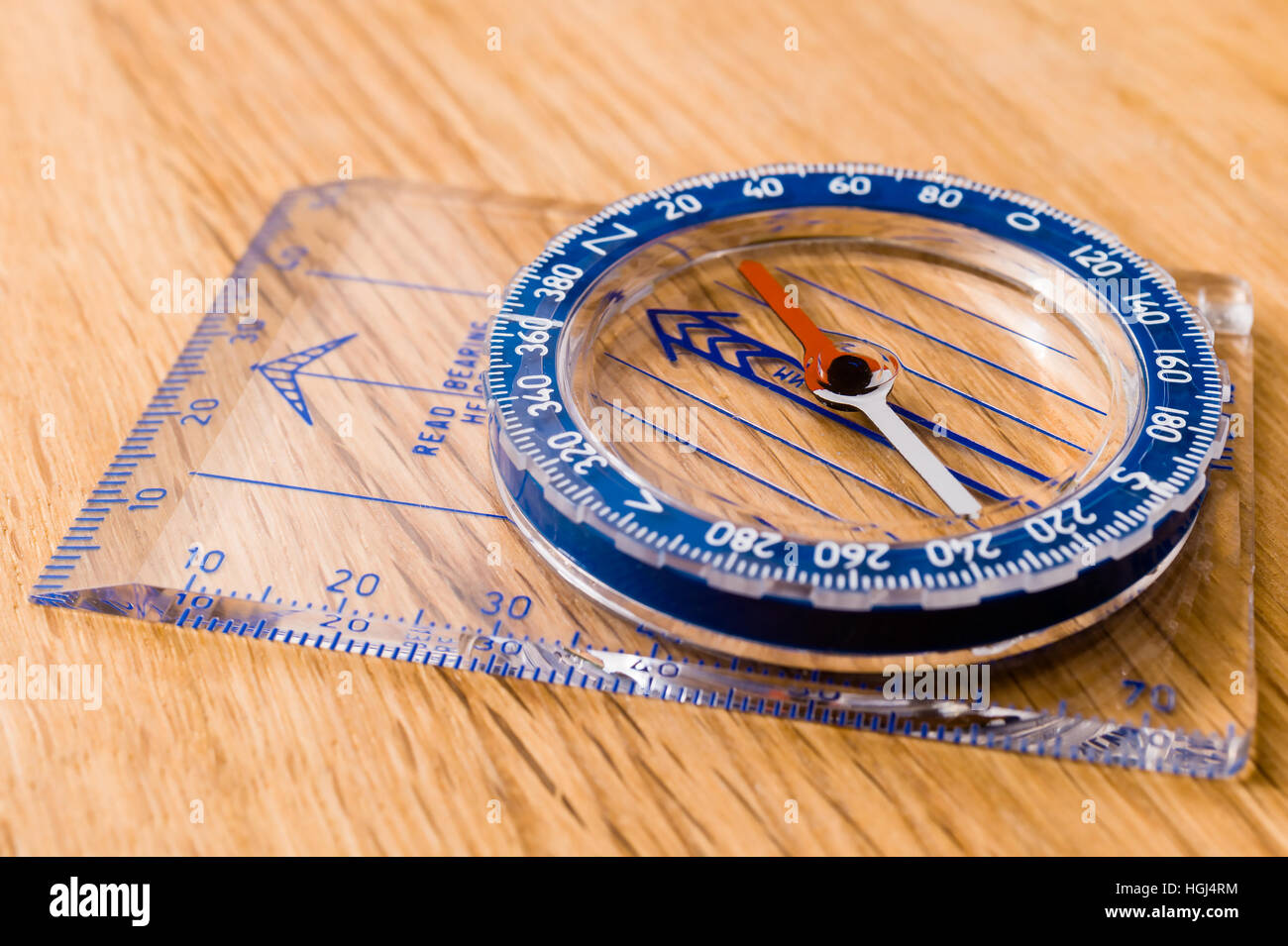 Small transparent compass on wooden table Stock Photo - Alamy