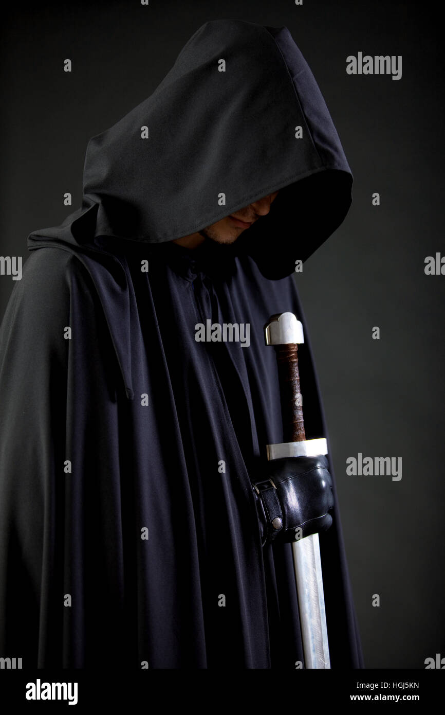 Portrait of a courageous warrior wanderer in a black cloak and sword in ...