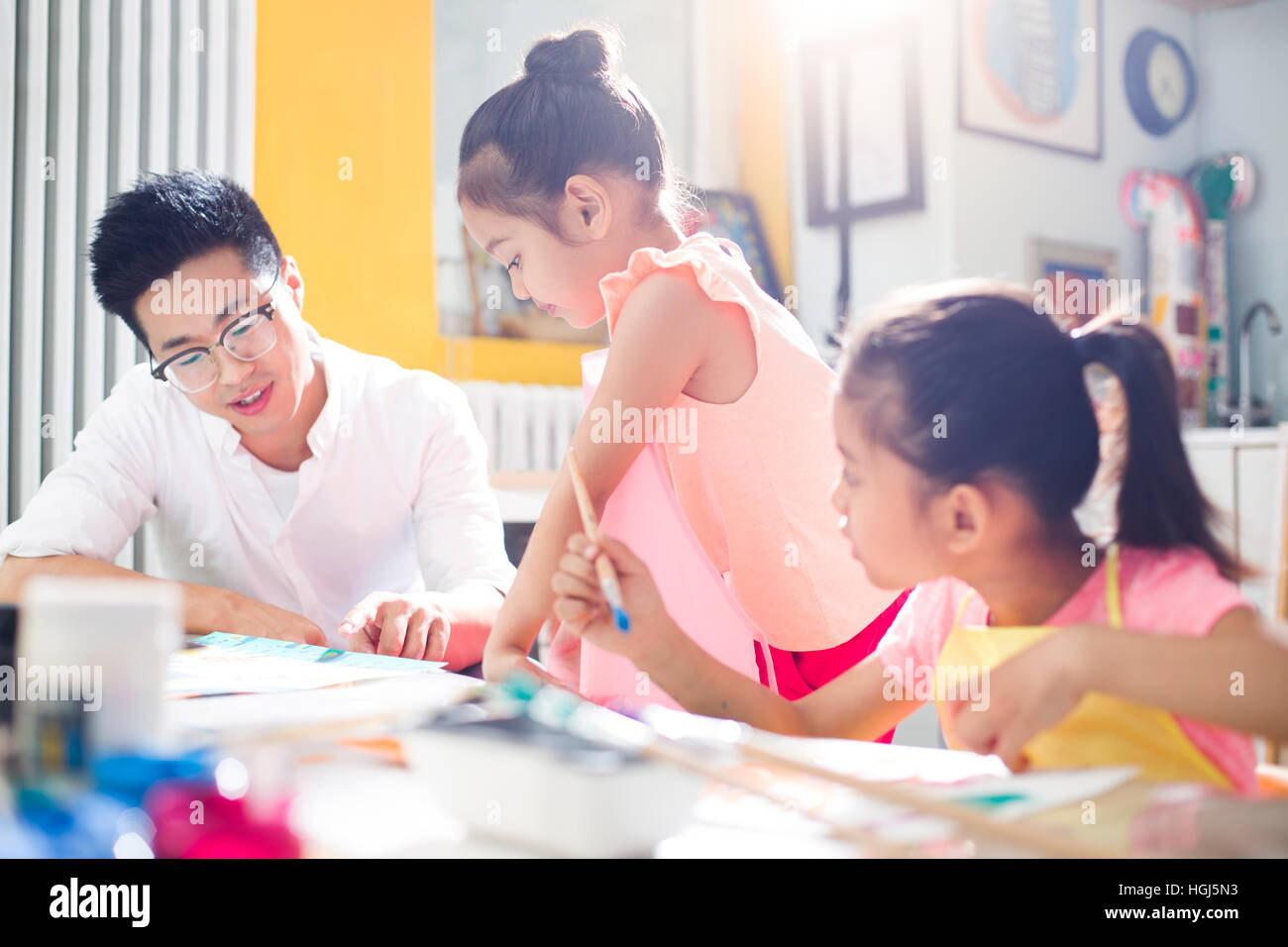 Little children painting in art class with teacher Stock Photo - Alamy