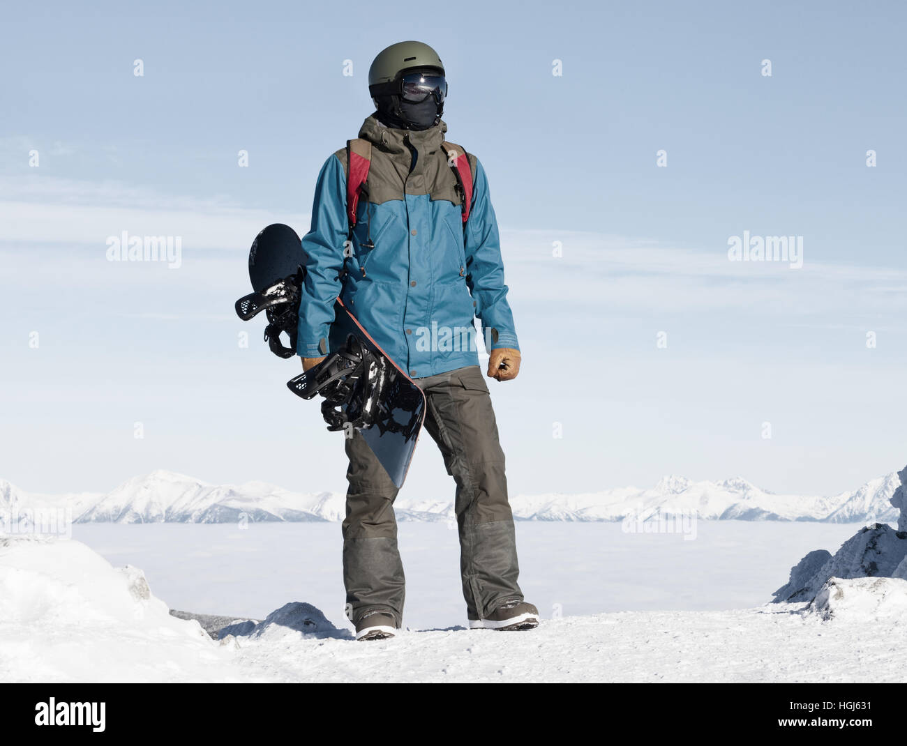 Man holding snowboard and enjoying the landscape at the top of the ...