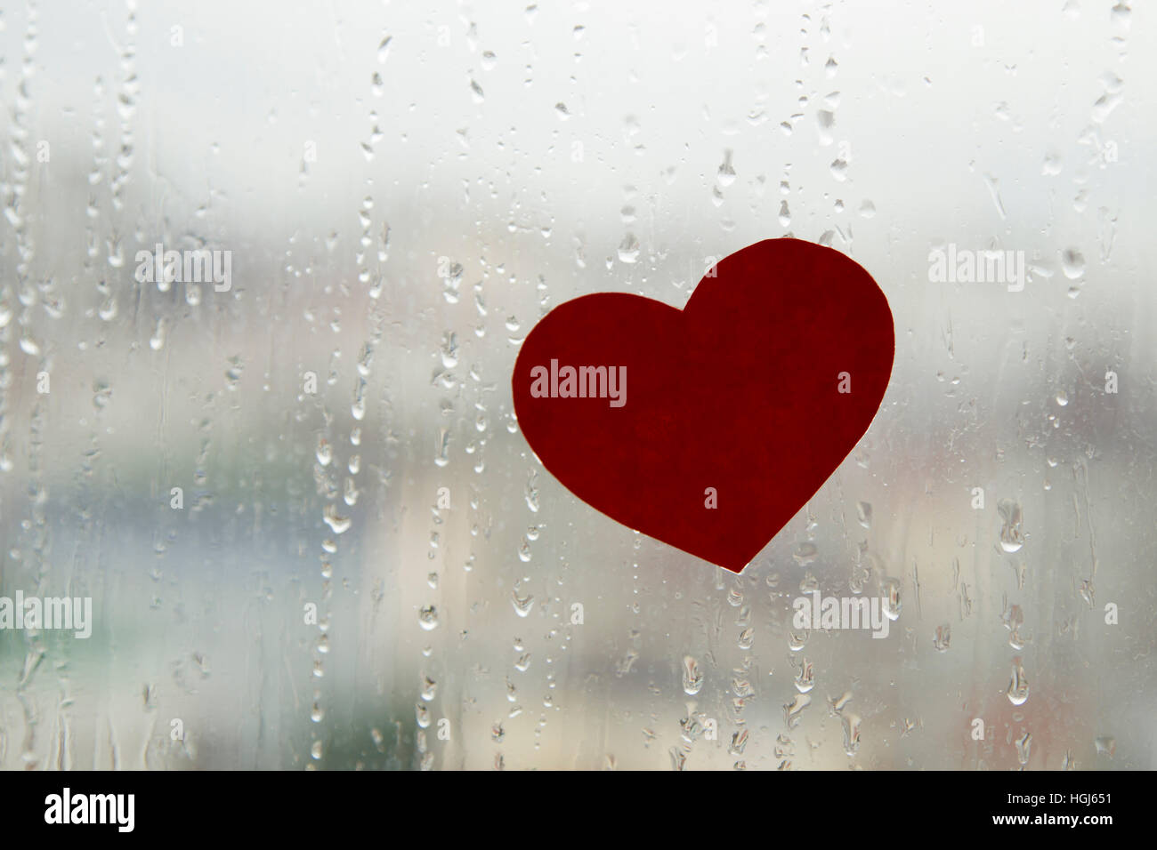 Red paper heart sticked on the wet window with rain drops Stock Photo ...
