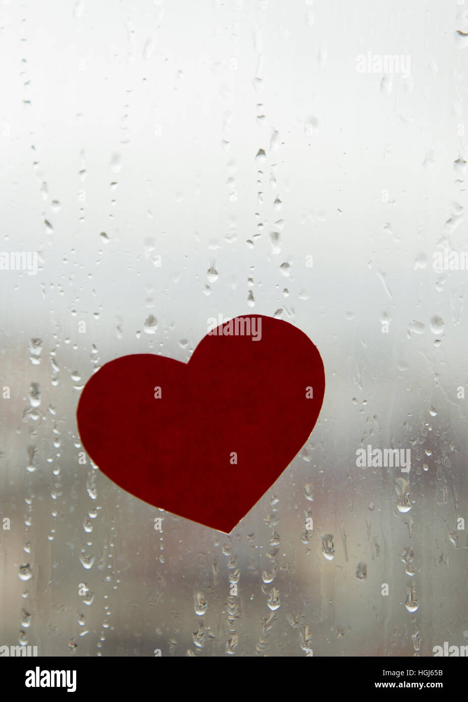 Red paper heart sticked on the wet window with rain drops Stock Photo ...