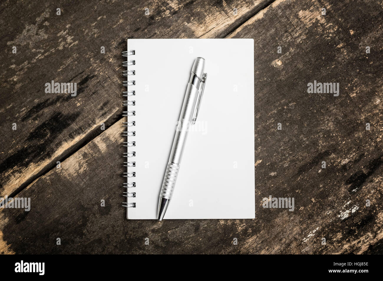 Open blank notebook on grunge wood background with silver pencil ...