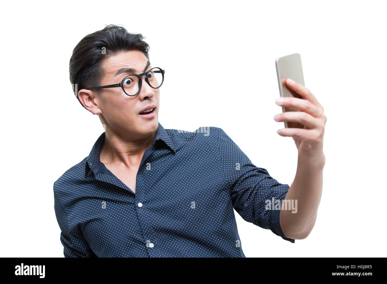 Angry young man looking at smart phone Stock Photo - Alamy