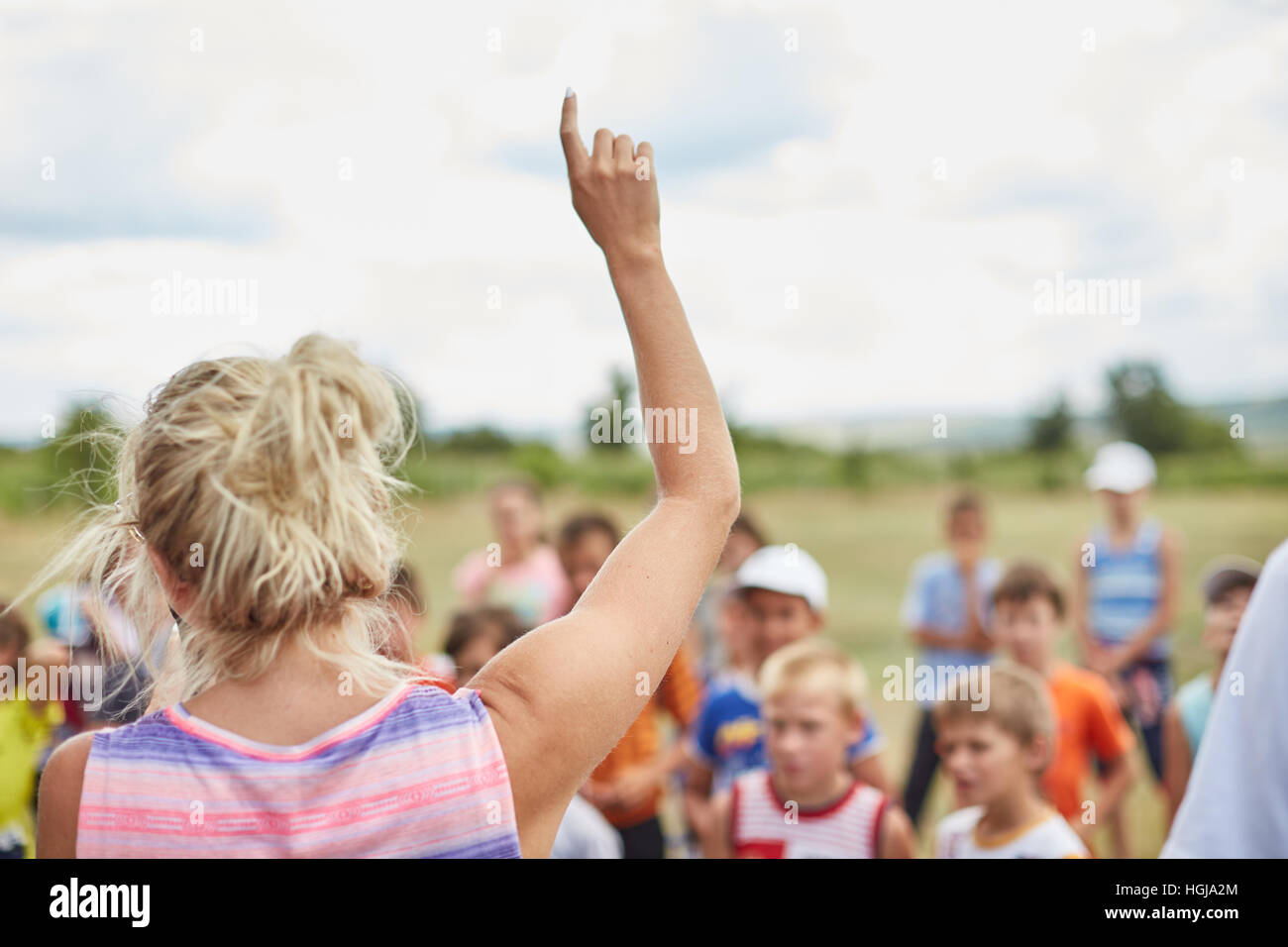 Young woman speaker in front of children crowd. Kids summer camp Stock ...