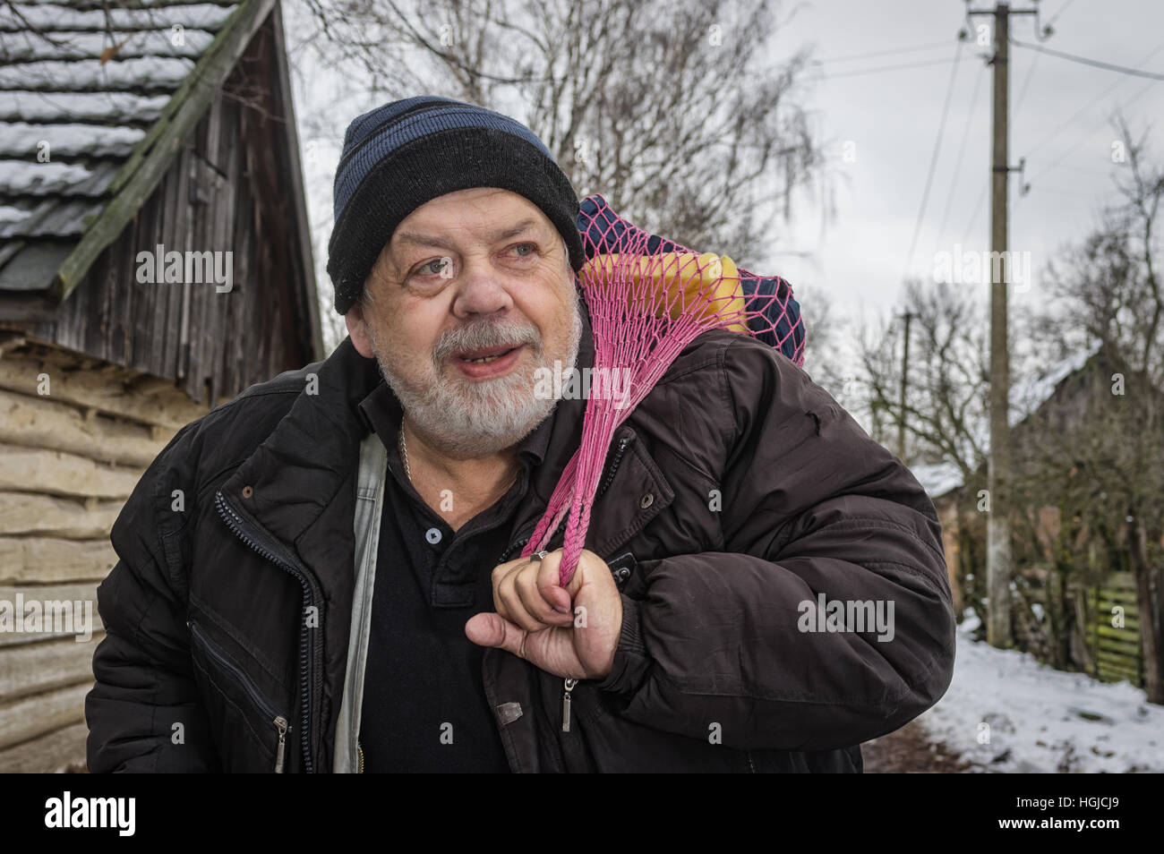 Outdoor portrait of positive Ukrainian peasant standing on a rural ...