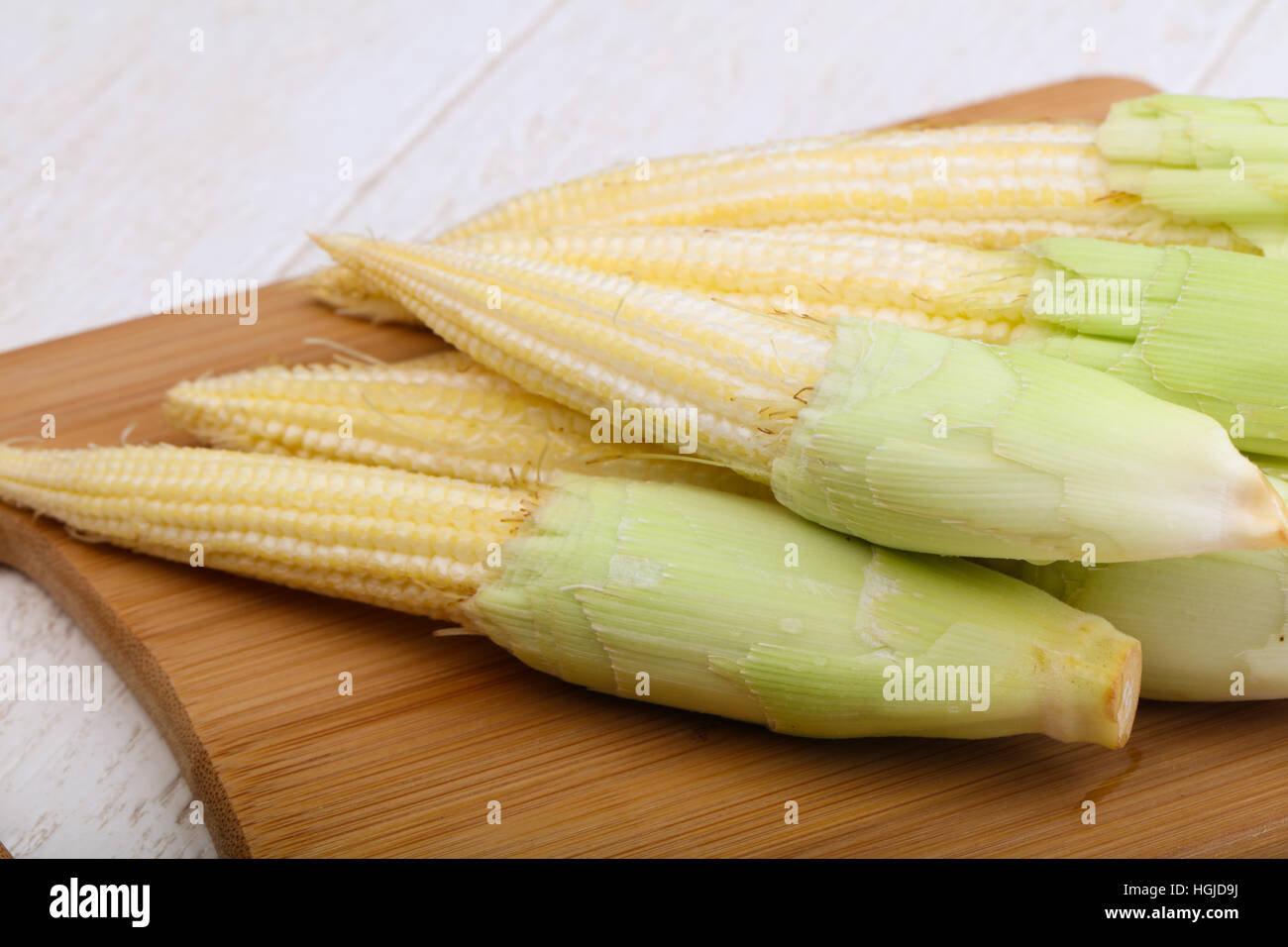 Fresh baby corn heap on the wood background Stock Photo - Alamy