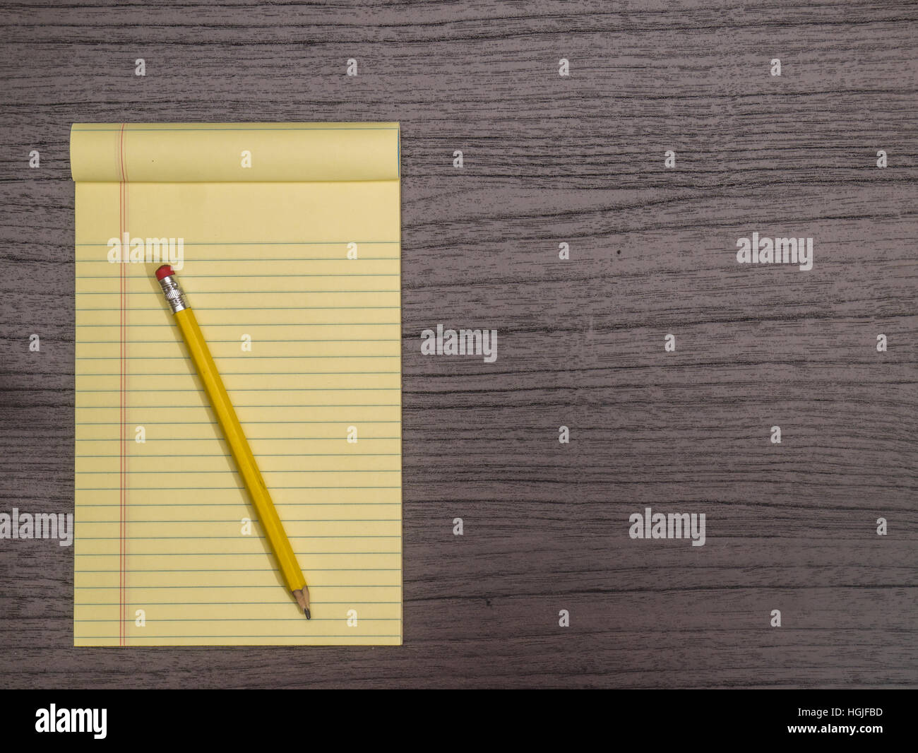 Dark Wood Desk, Yellow Pad, Pencil on Pad Stock Photo - Alamy