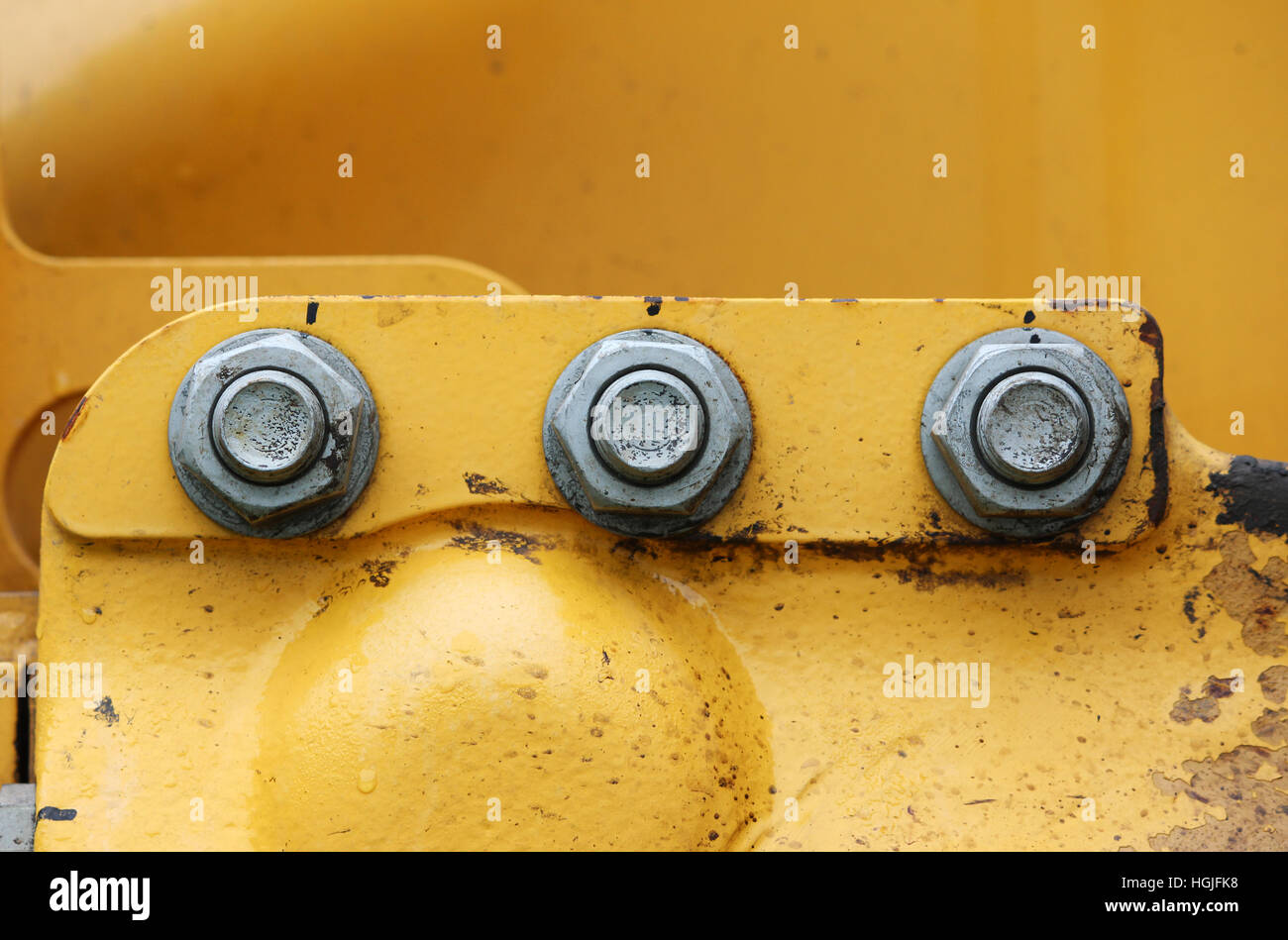 cap screws and holes in the yellow background - on the construction ...