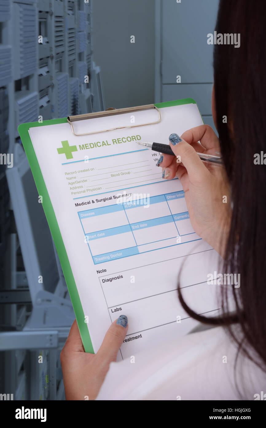 Female doctor is writing patient information to medical record form ...