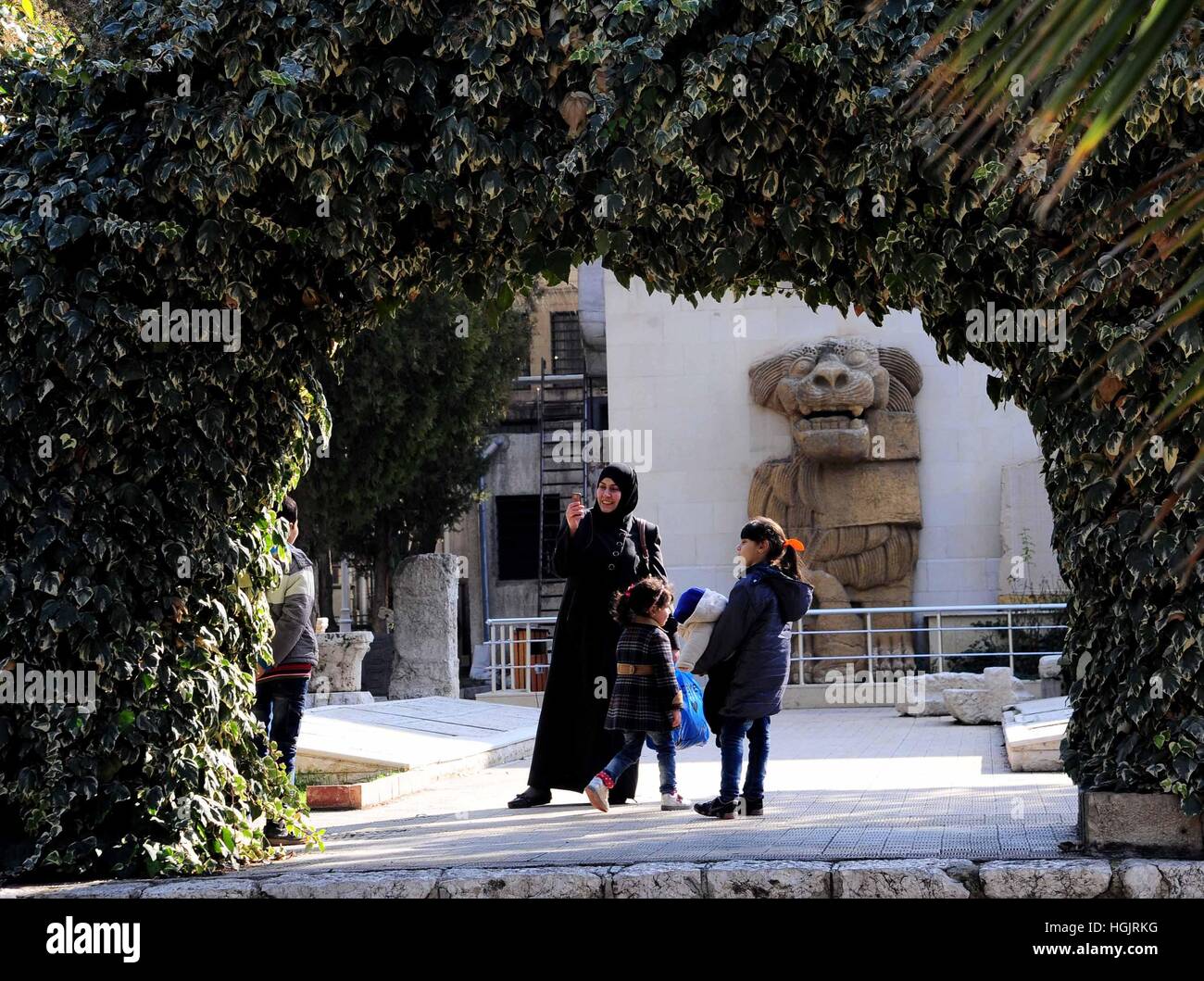 Damascus, Syria. 22nd Jan, 2017. A Syrian woman walks with her two kids ...