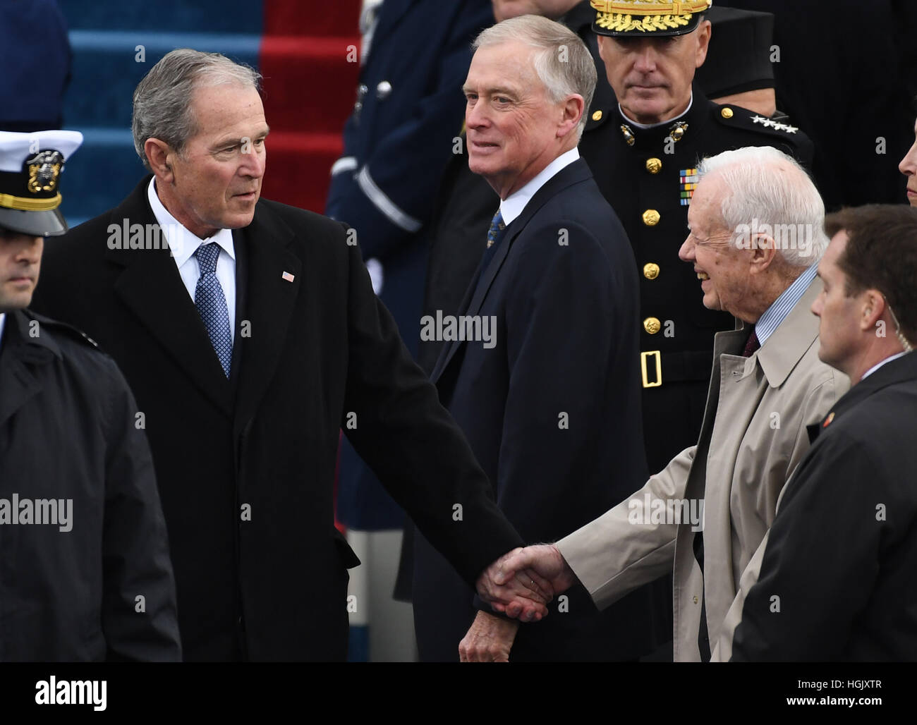 Former President George W. Bush grabs the hand of former President ...