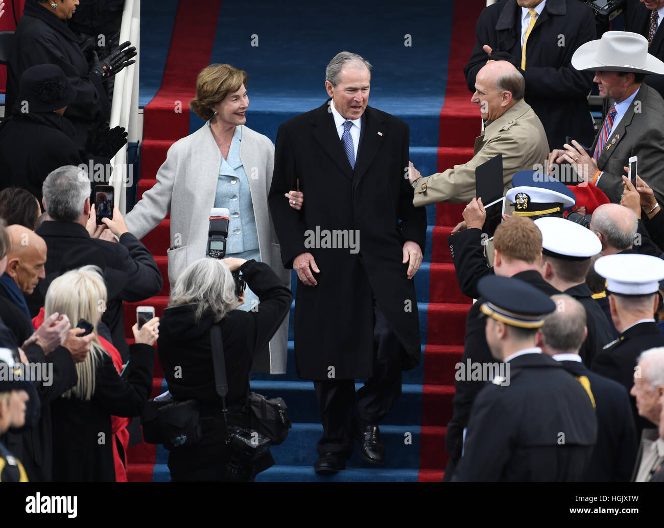 Former President George W. Bush and wife Laura walk down the steps ...