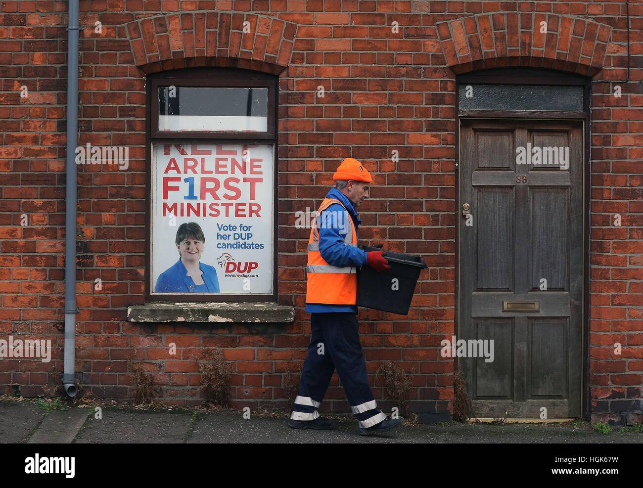 A refuse collector walks past a poster at the DUP headquarters in ...