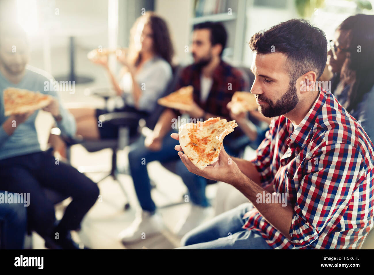 Coworkers eating pizza during work break at office Stock Photo - Alamy