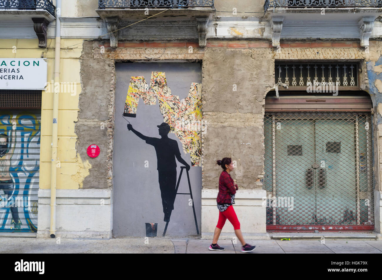 A woman walks past a street mural by spanish artist Pejac at the Soho ...