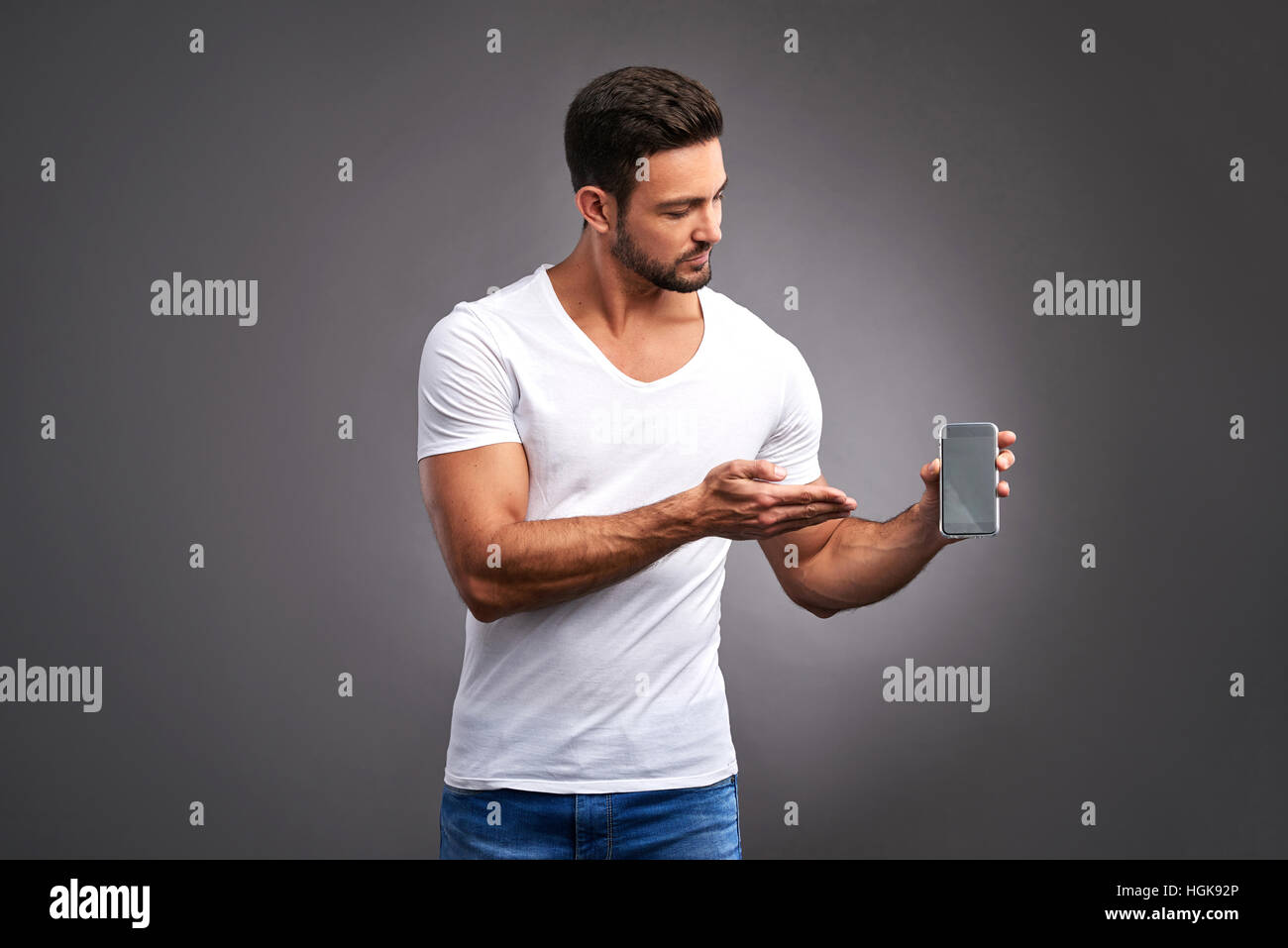 A confident handsome young man showing his phone to the camera Stock ...