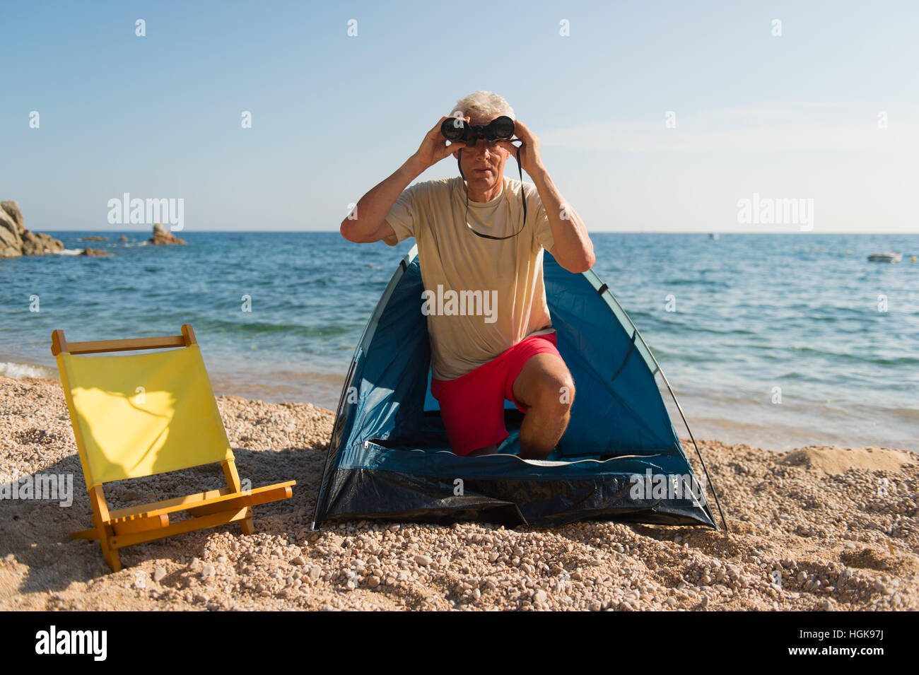 Man with spy glasses camping at the beach Stock Photo - Alamy