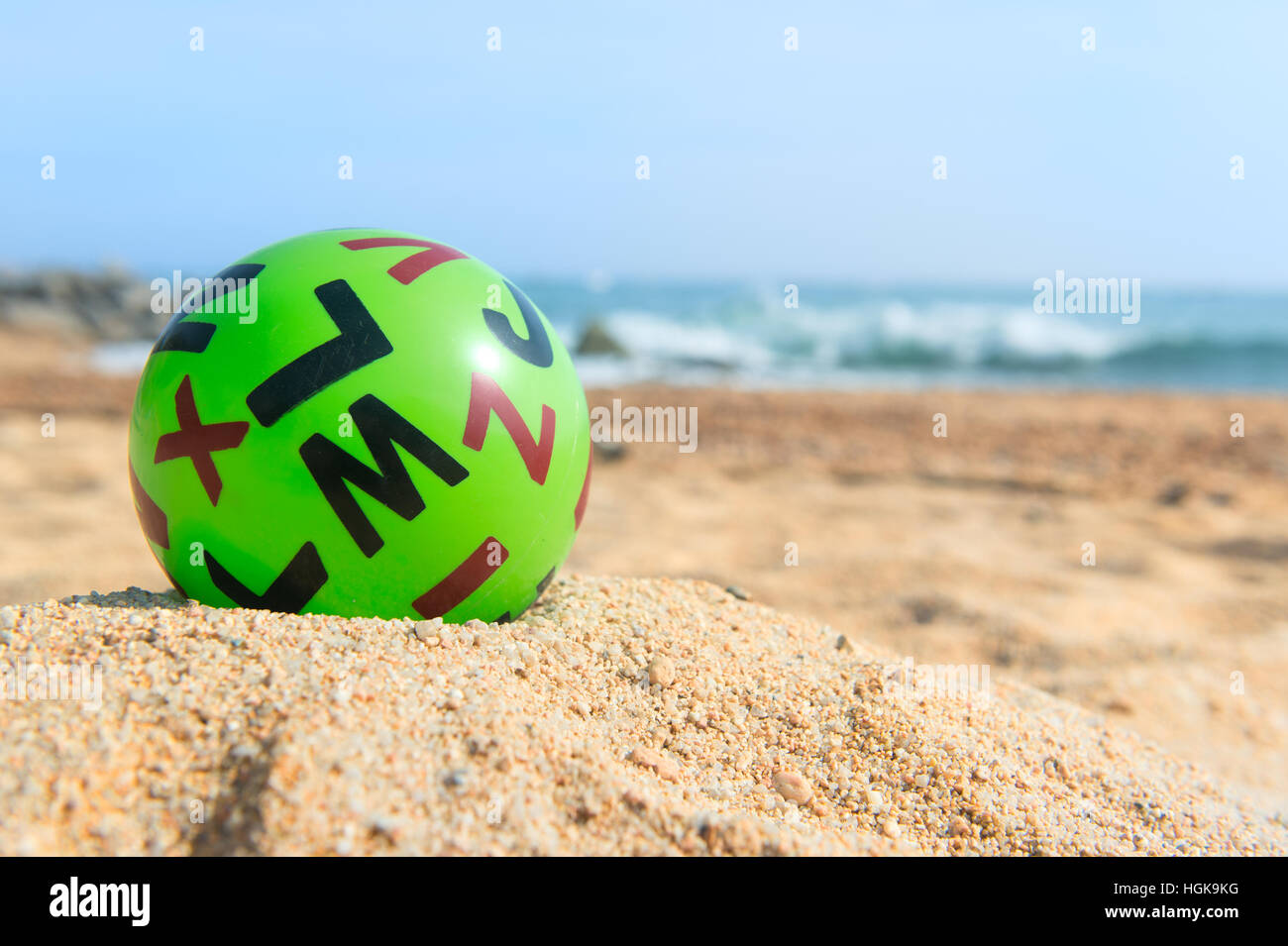 Green toy ball with letters at the beach Stock Photo - Alamy