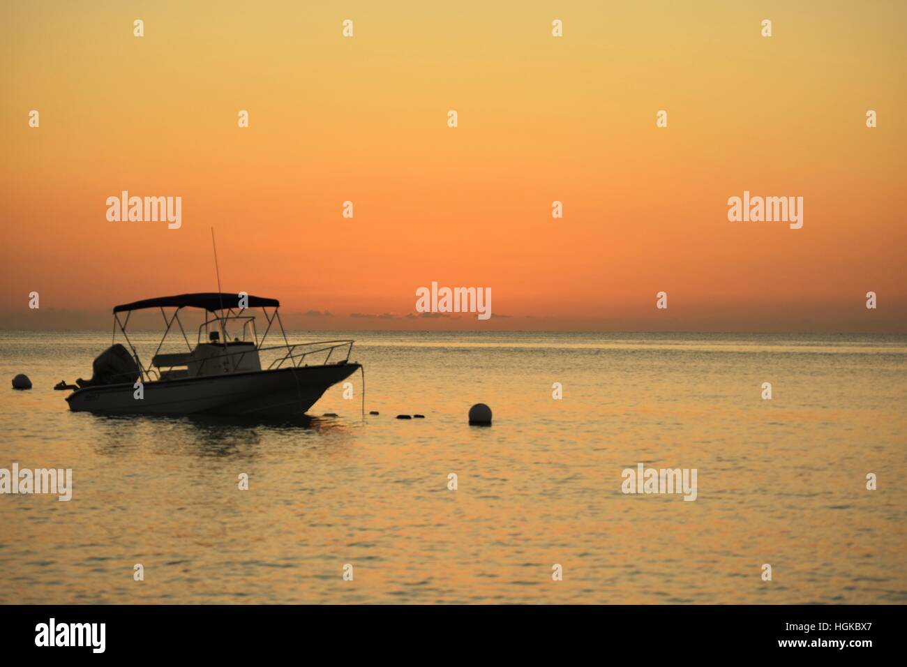 boat on the calm Caribbean ocean at sunset Stock Photo - Alamy