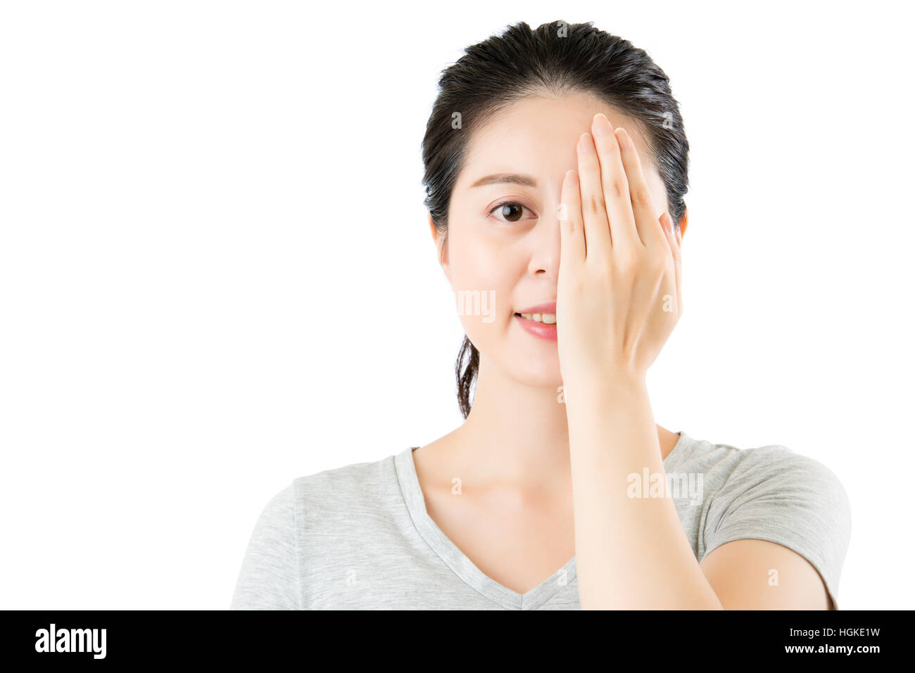 asian woman reviewing eyesight. closing one eye with hand and ...