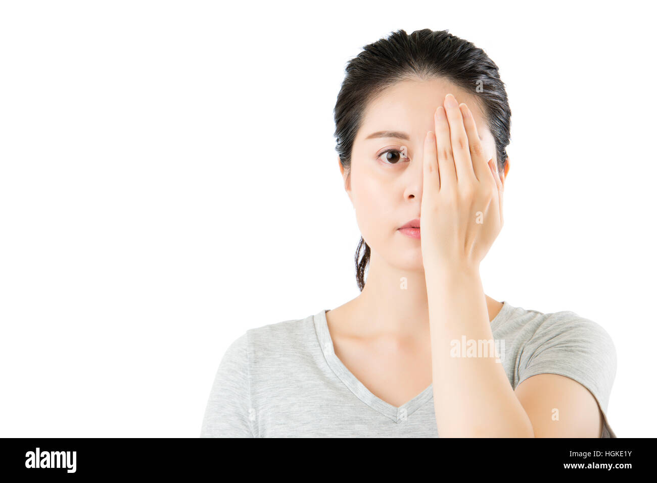 asian woman reviewing eyesight. closing one eye with hand and ...