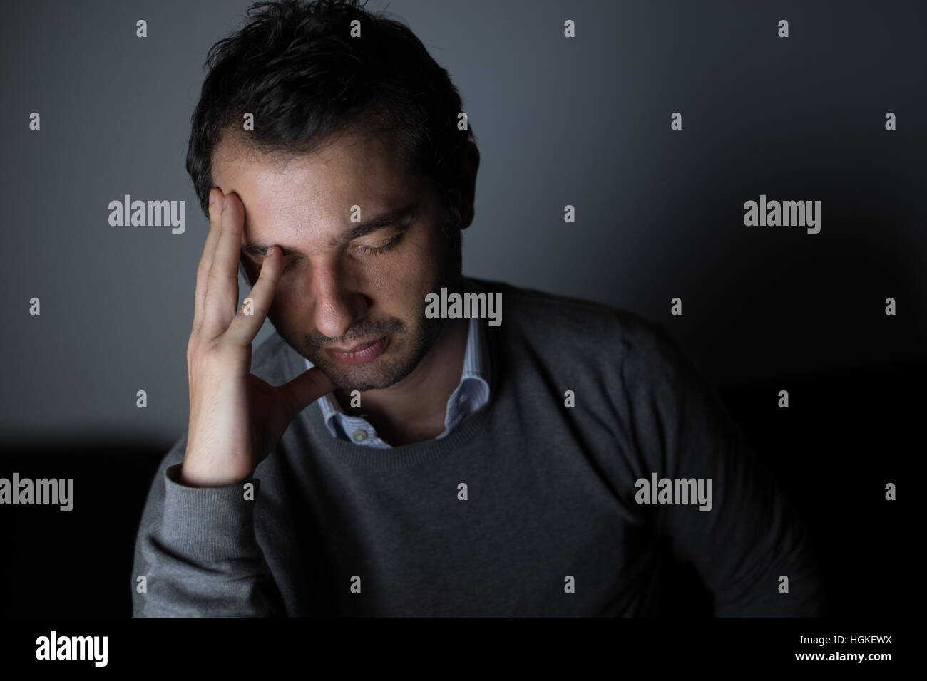 Portrait of thoughtful sad man alone in the dark Stock Photo - Alamy