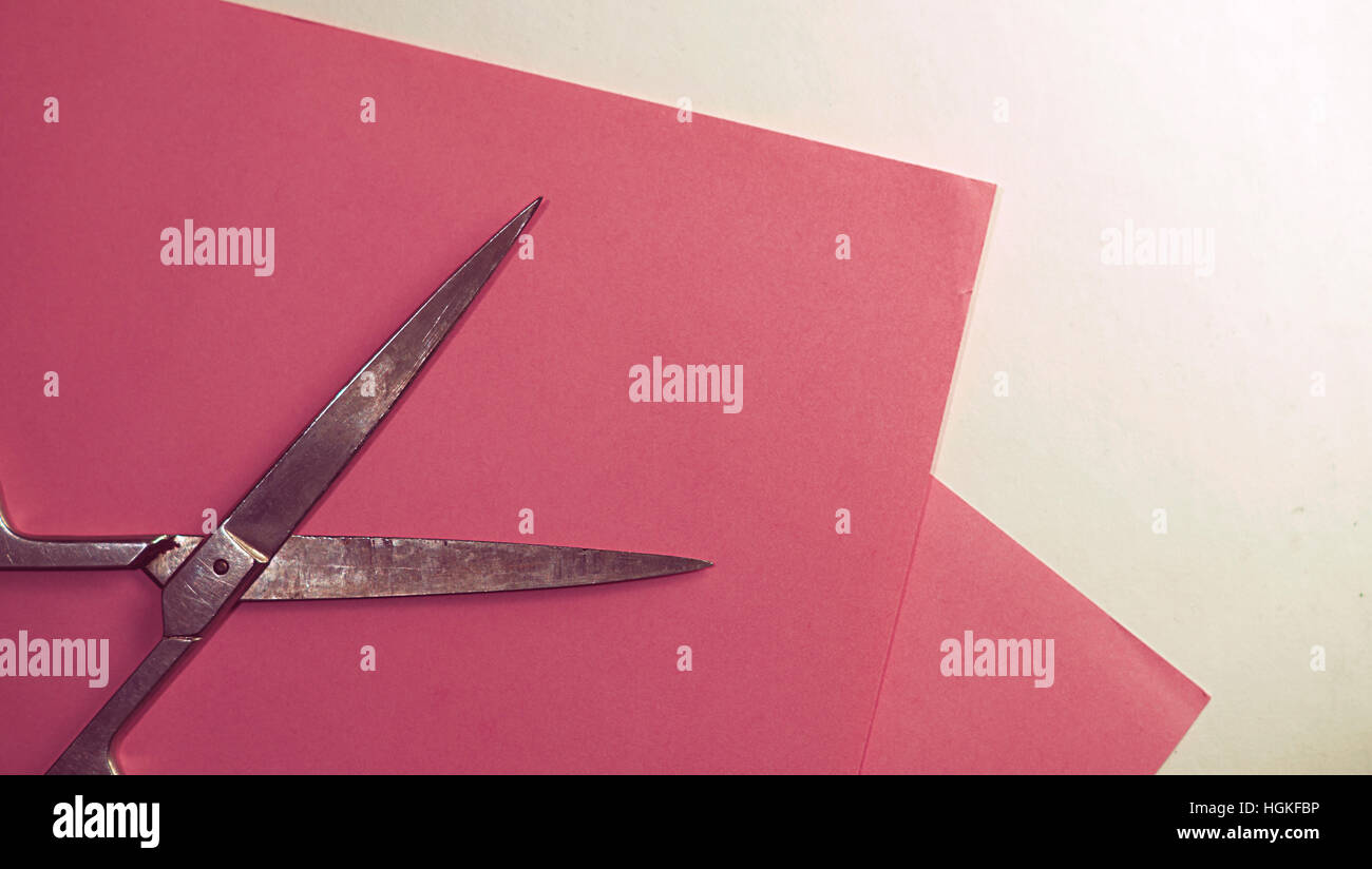 Scissor on pink paper on white background Stock Photo - Alamy