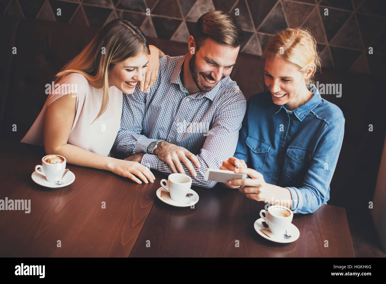 Young people sitting in cafe, drinking coffee and having fun Stock ...