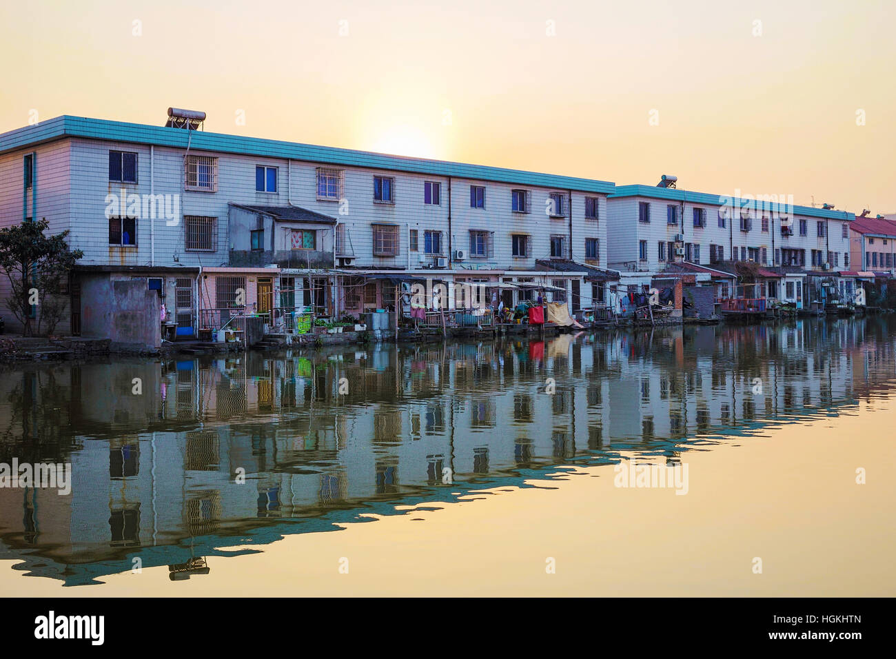 Old apartment buildings by a river in China at sunset Stock Photo - Alamy