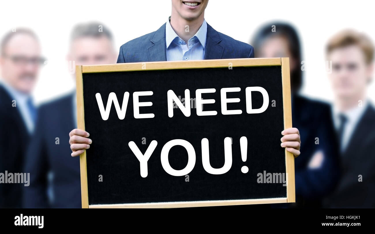 young businessman holding a sign with the words We Need You and group ...