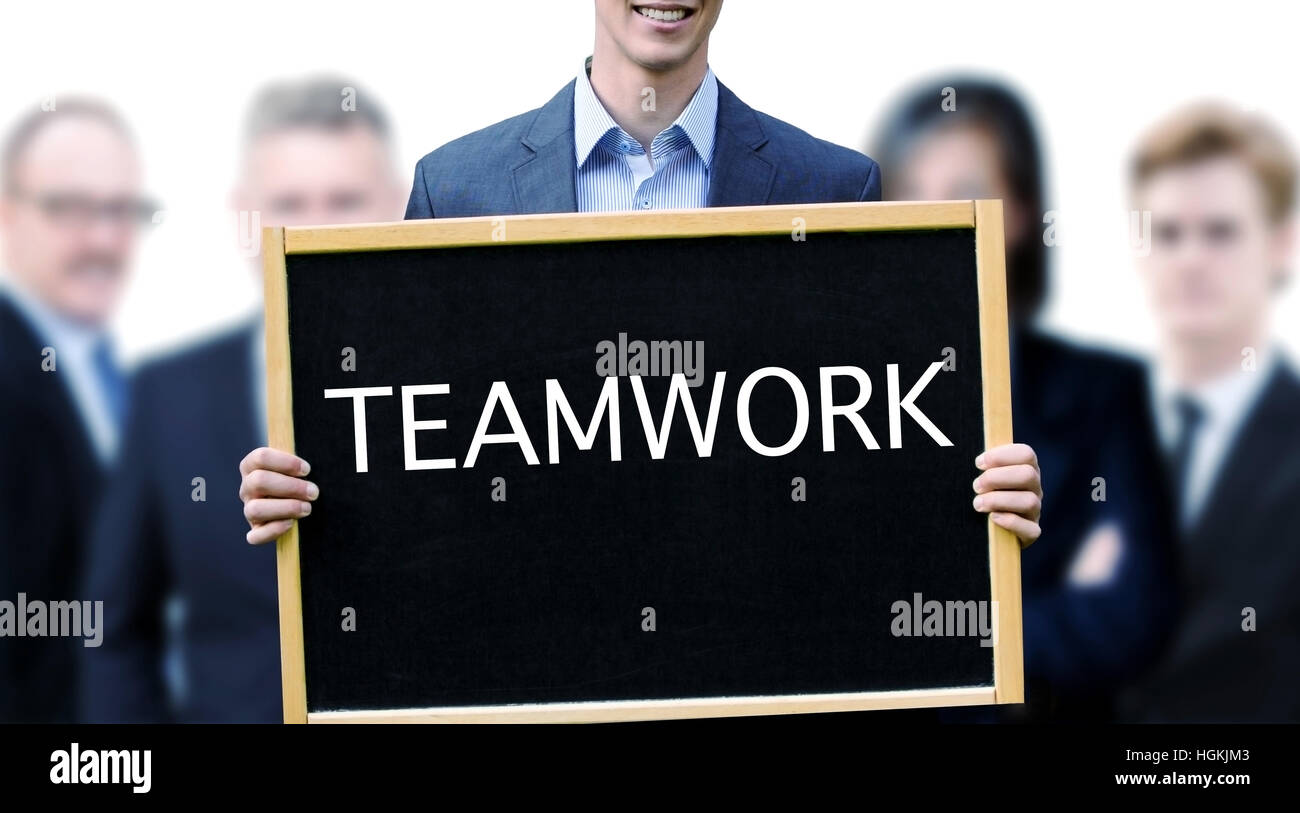 young businessman holding a sign with the word Teamwork and group of ...