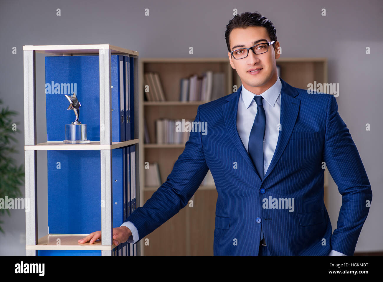 Young man standing next to the shelf with folders Stock Photo - Alamy