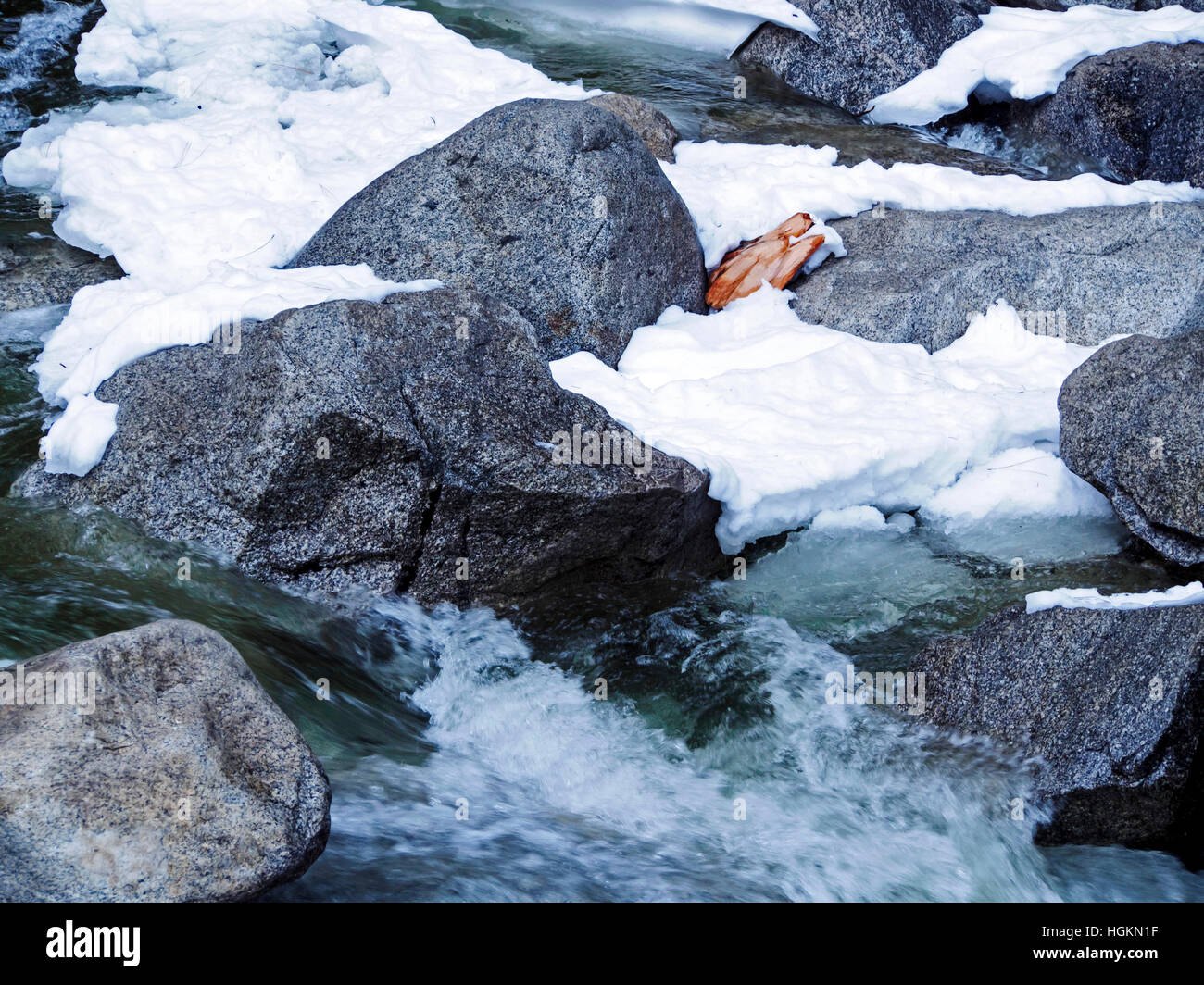 Snow, ice and granite boulders in a small creek in the Yosemite Valley ...