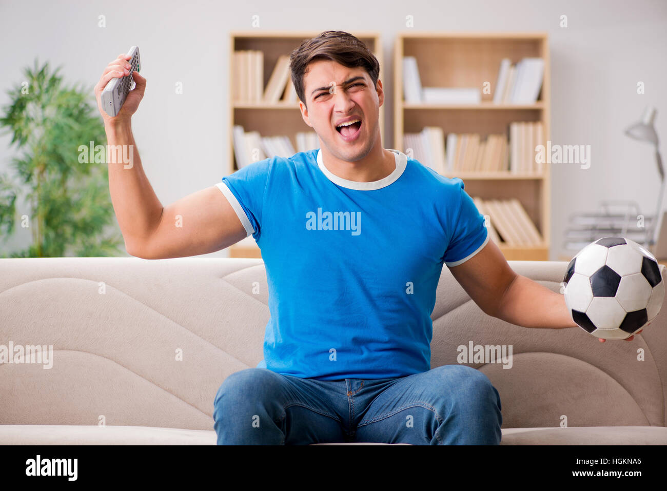 Man watching football at home Stock Photo - Alamy