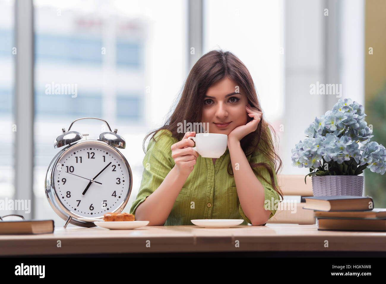 Student with gian alarm clock preparing for exams Stock Photo - Alamy