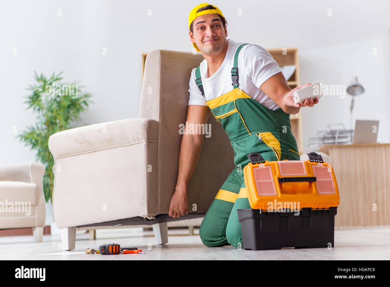 Worker repairing furniture at home Stock Photo - Alamy