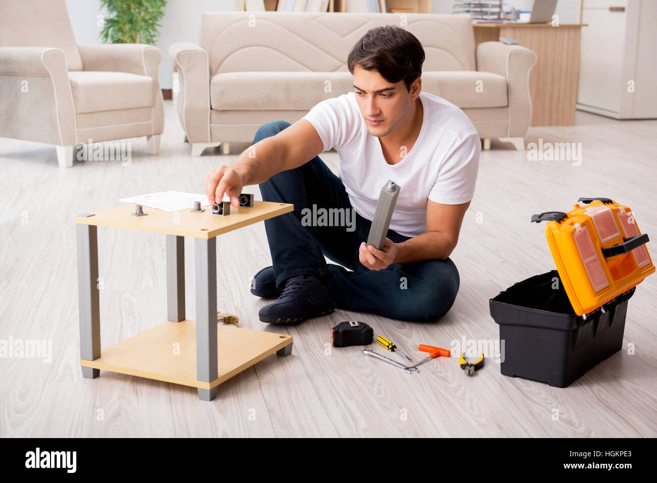 Man assembling shelf at home Stock Photo - Alamy