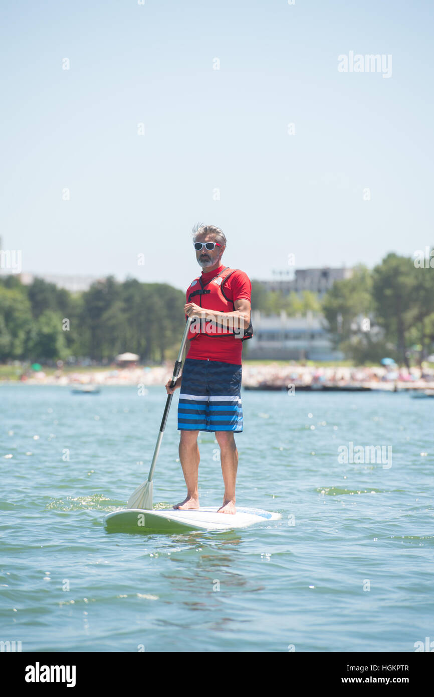 man enjoying a ride on the lake with paddleboard Stock Photo - Alamy