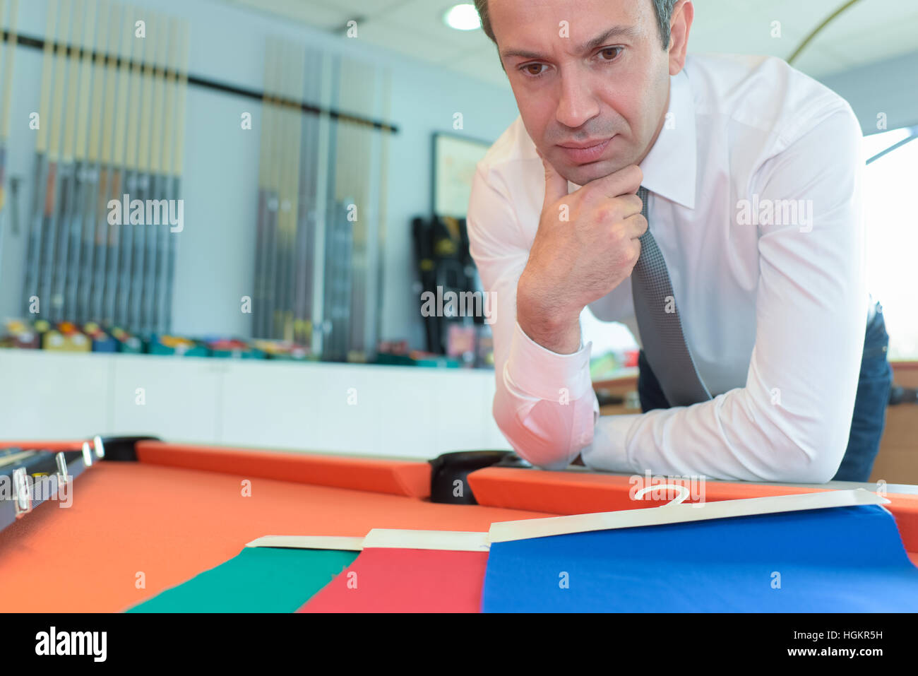 Man pondering color scheme for pool table Stock Photo - Alamy