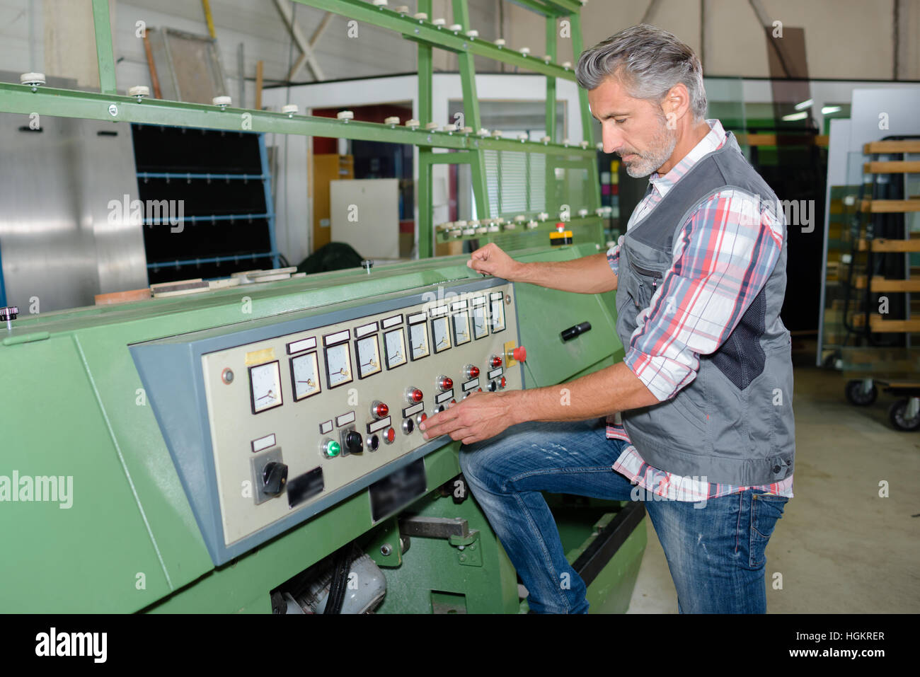 Mature man operating industrial machine Stock Photo - Alamy