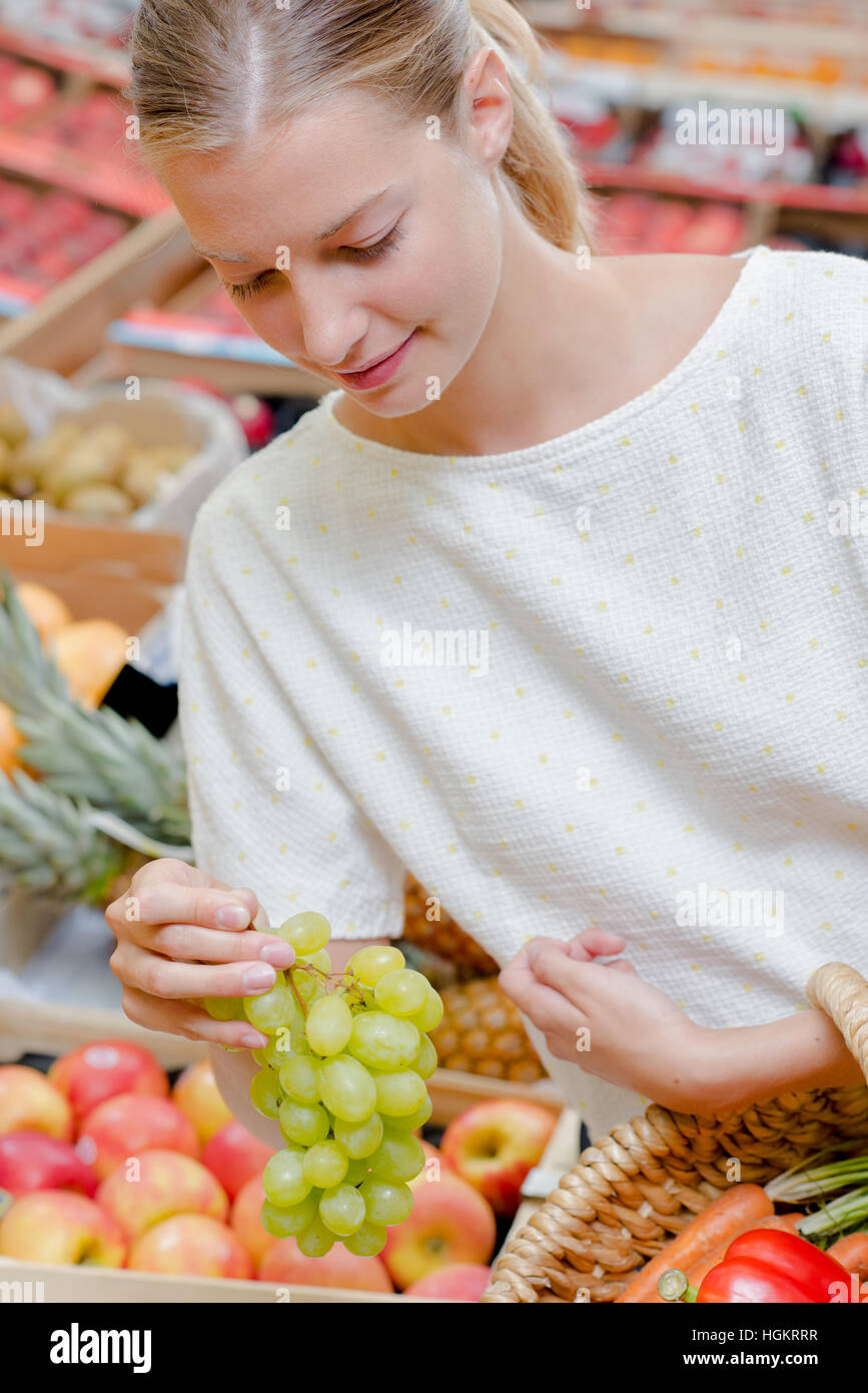 Young woman buying grapes Stock Photo - Alamy