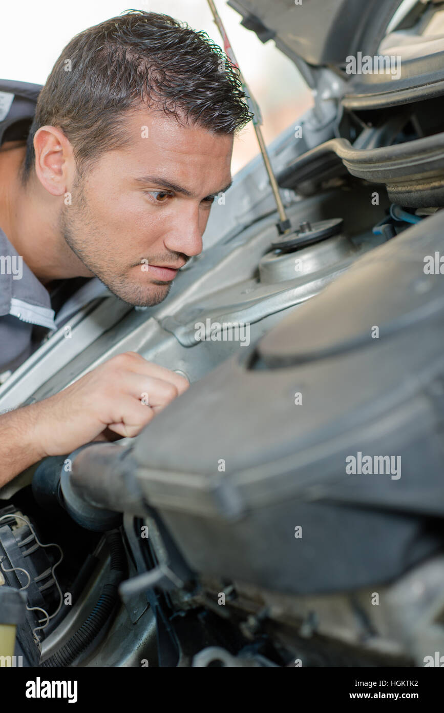 Young mechanic checking a car engine Stock Photo - Alamy