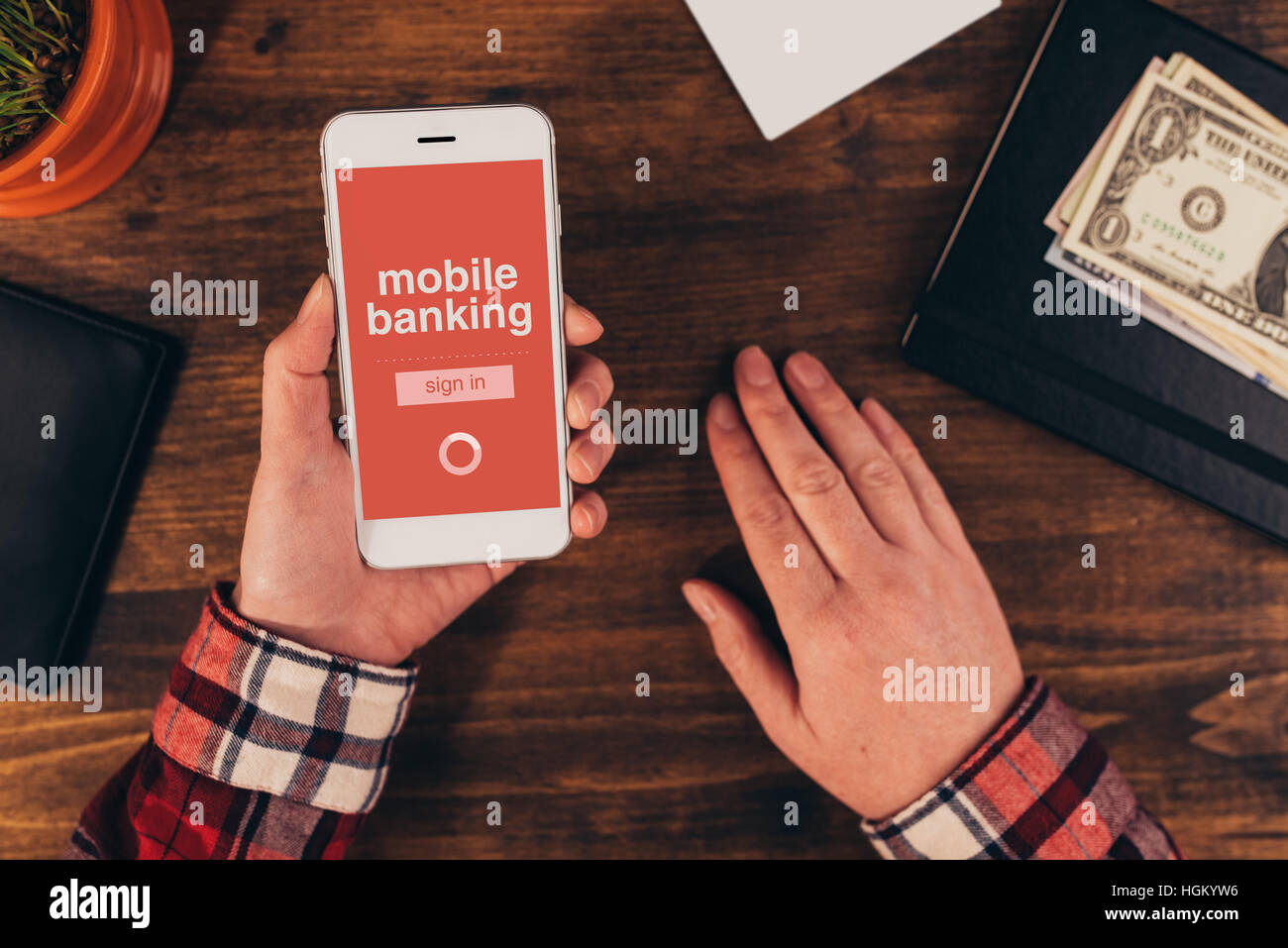 Woman using mobile banking app on smart phone in the office, top view ...